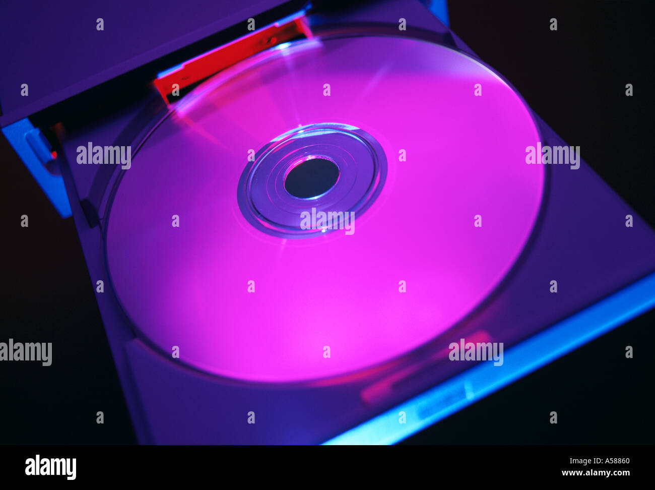 Compact disc on Cd player tray lit with purple light Stock Photo - Alamy