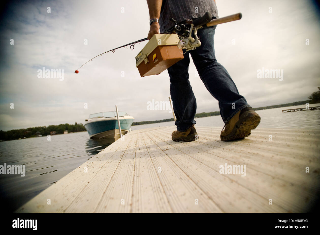 Man walking on a fishing dock Stock Photo - Alamy