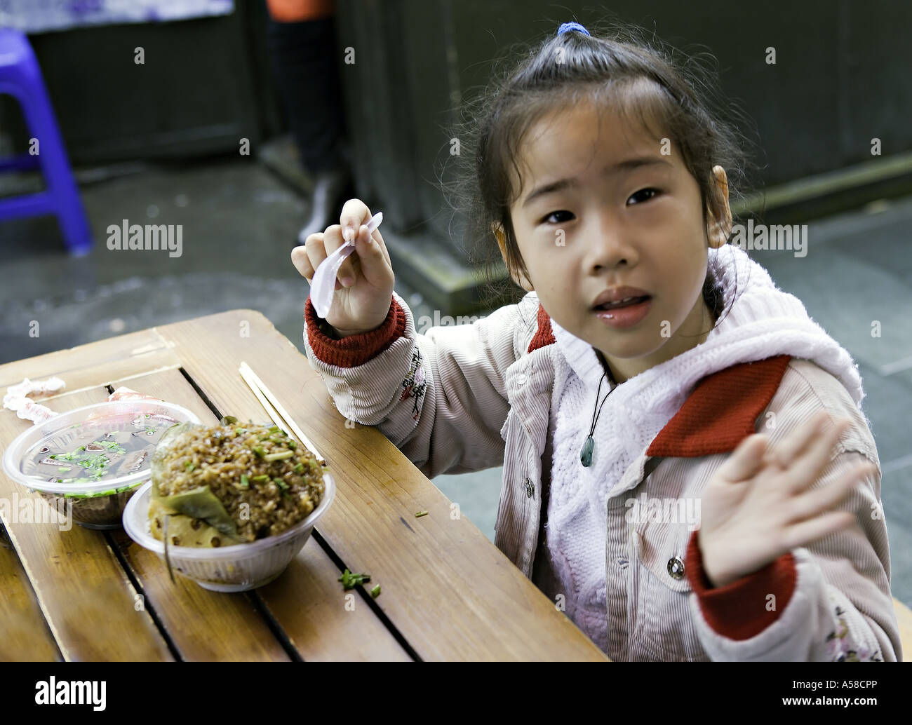 CHINA SHANGHAI Young Chinese girl eating a lunch of fried rice and miso ...