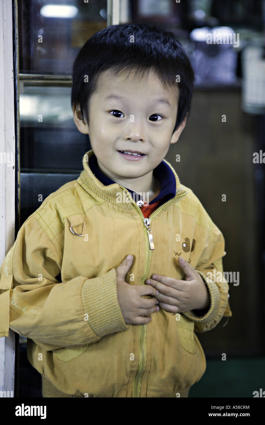 CHINA SHANGHAI Young Chinese school age boy in a yellow jacket smiles ...