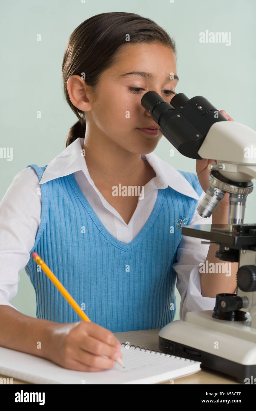 Hispanic girl looking through microscope Stock Photo - Alamy