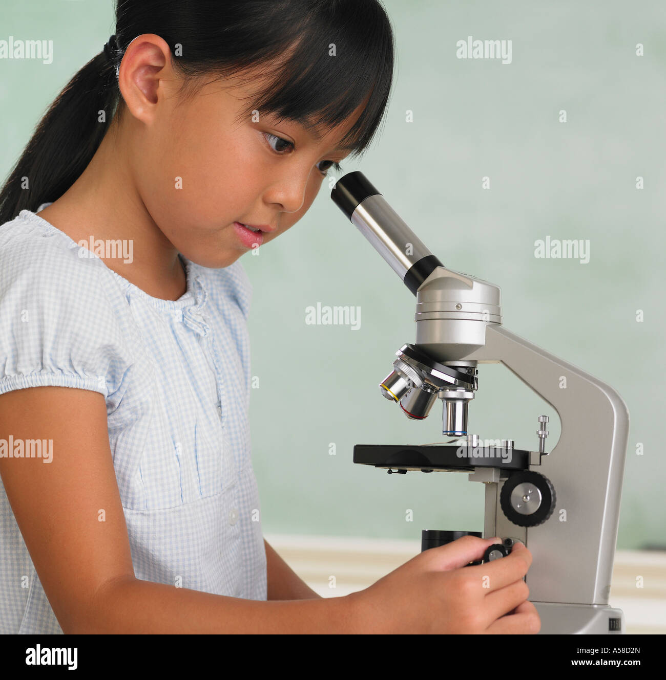 Young Asian girl looking through microscope Stock Photo - Alamy