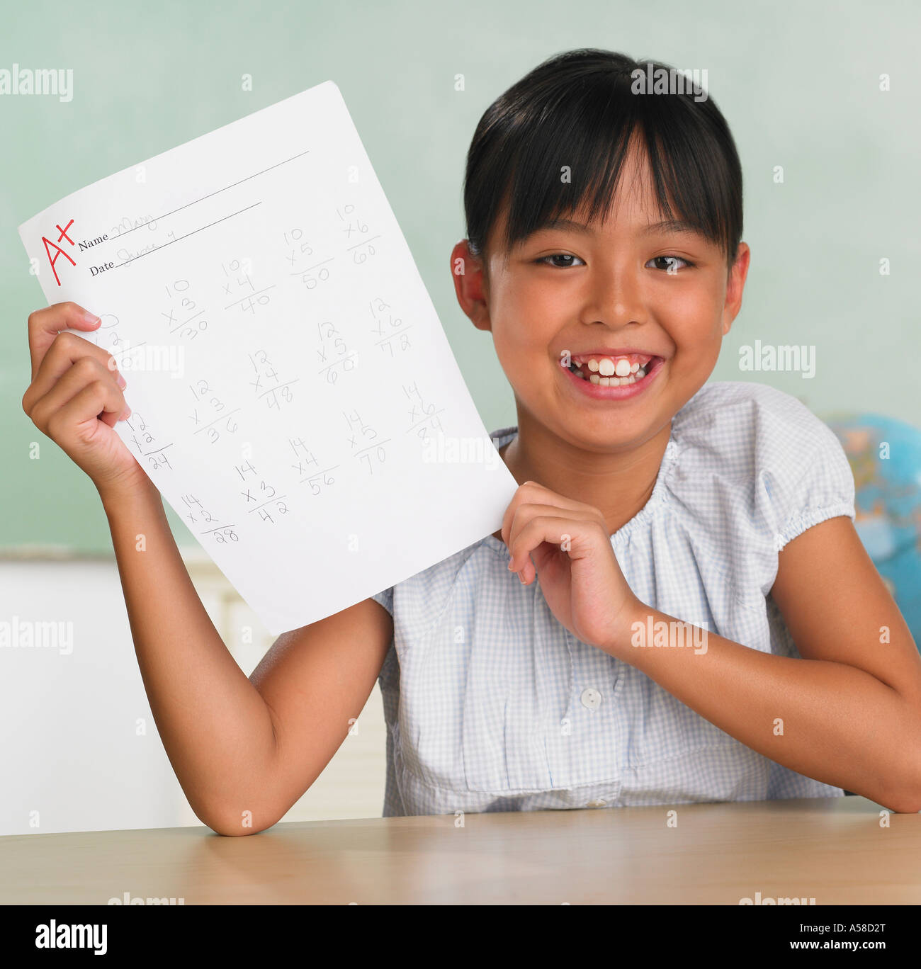 Asian girl holding up school paper with A Stock Photo - Alamy