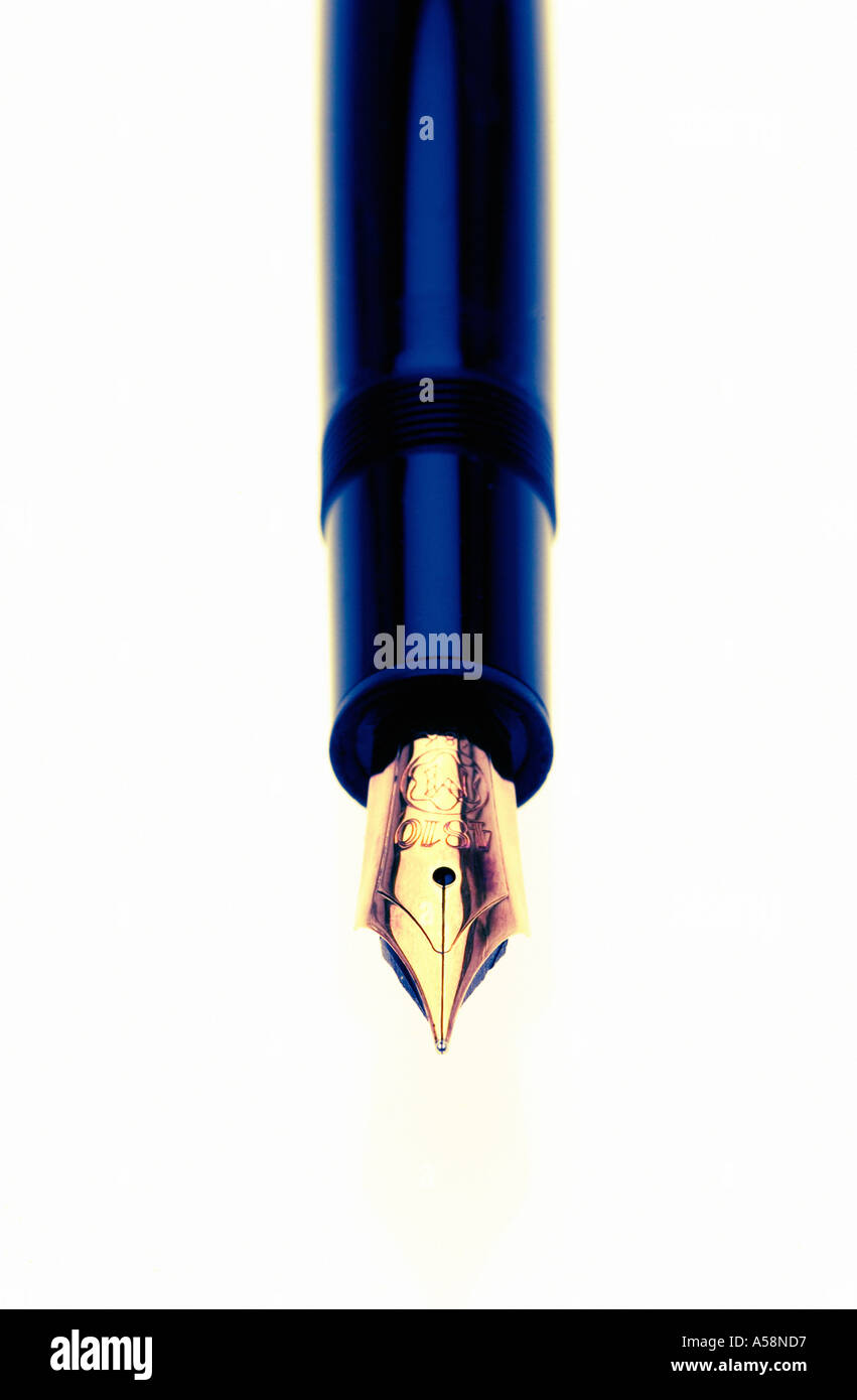 Close-up of the gold nib of a black fountain pen against white ...