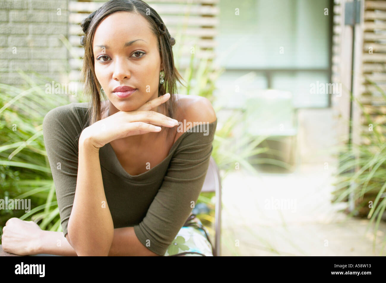 Portrait of woman resting head on hand outdoors Stock Photo - Alamy