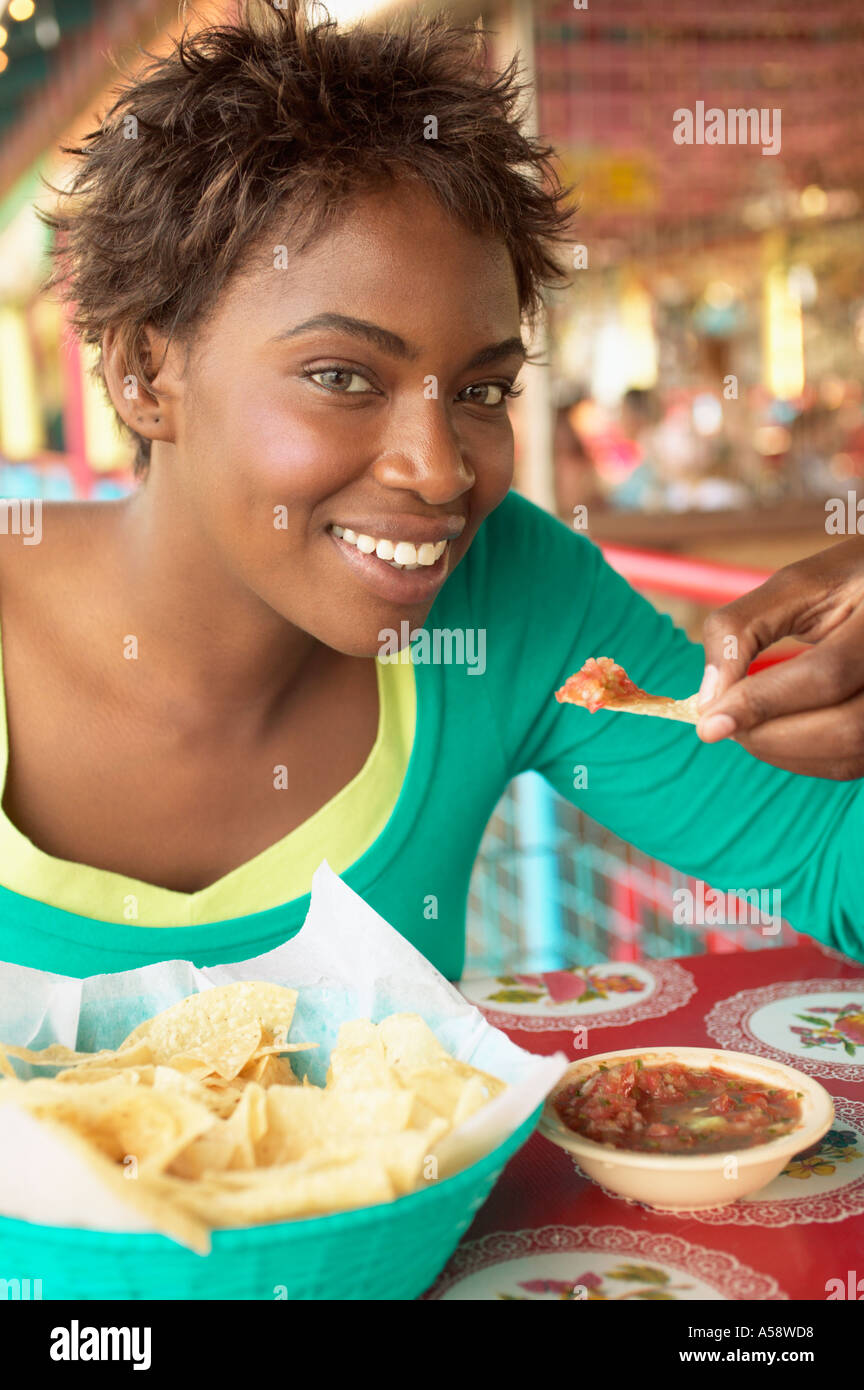 Woman eating chips and salsa Stock Photo - Alamy