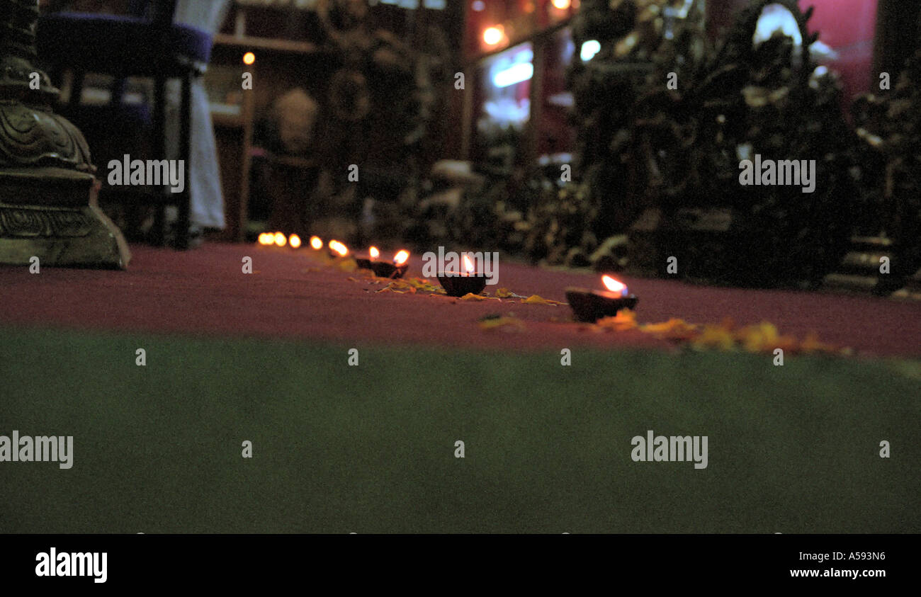 Burning candles and flower petals on shop floor at Tihar Fistival of ...