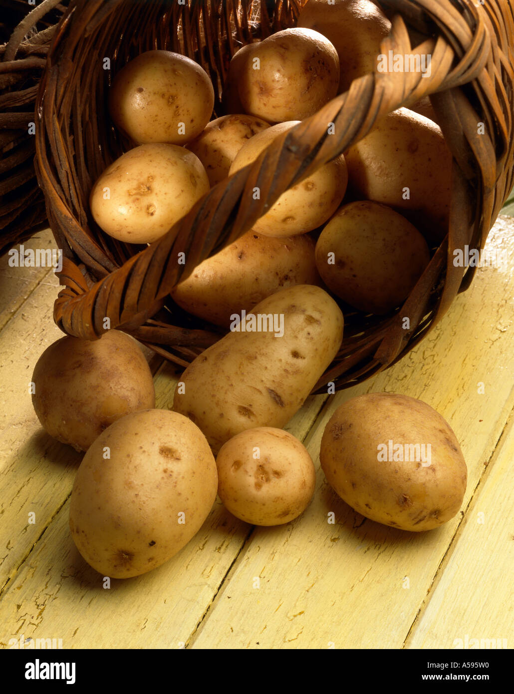 Nadine potatoes falling out of wicker basket Stock Photo - Alamy