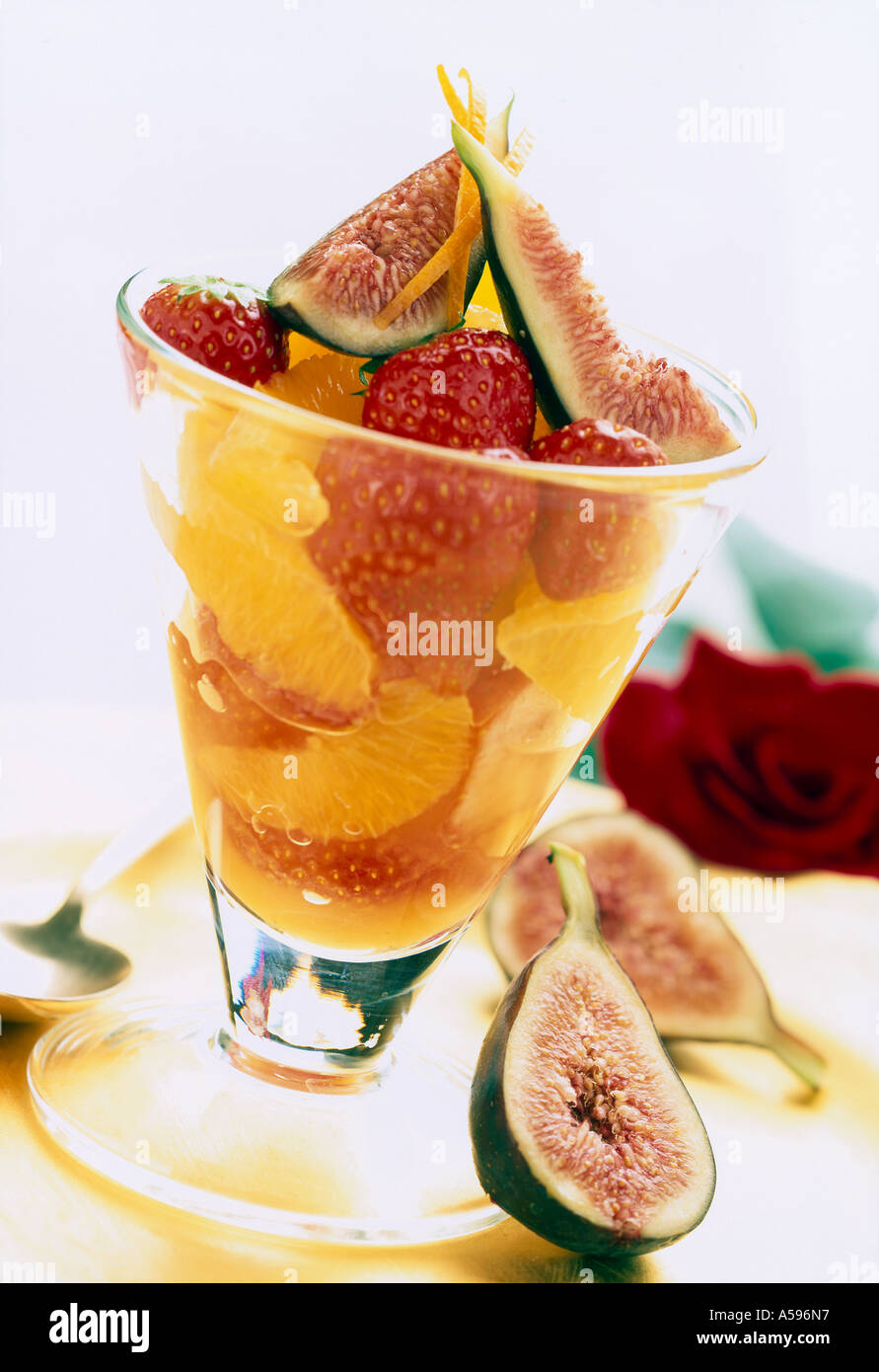 Single glass of fruit salad - figs, strawberries and orange segments in ...