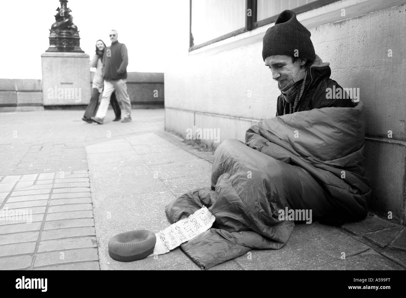 A homeless person sitting next a building on the south bank of the ...