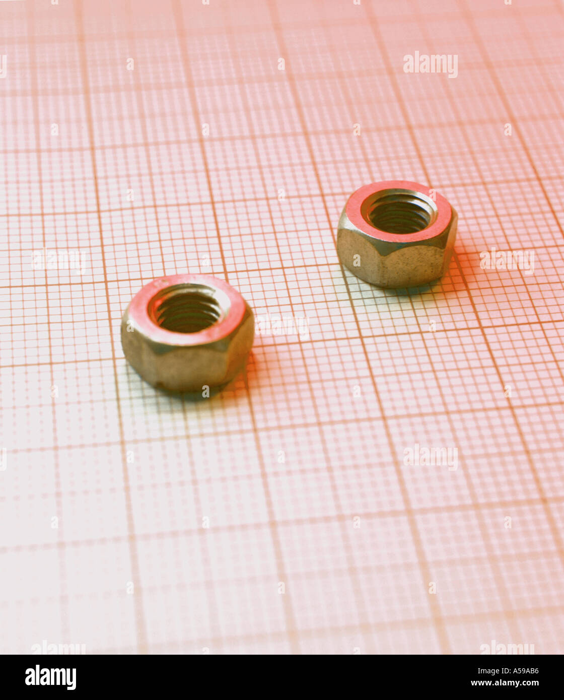 Engineering study; two galvanised steel nuts on graph paper Stock Photo ...