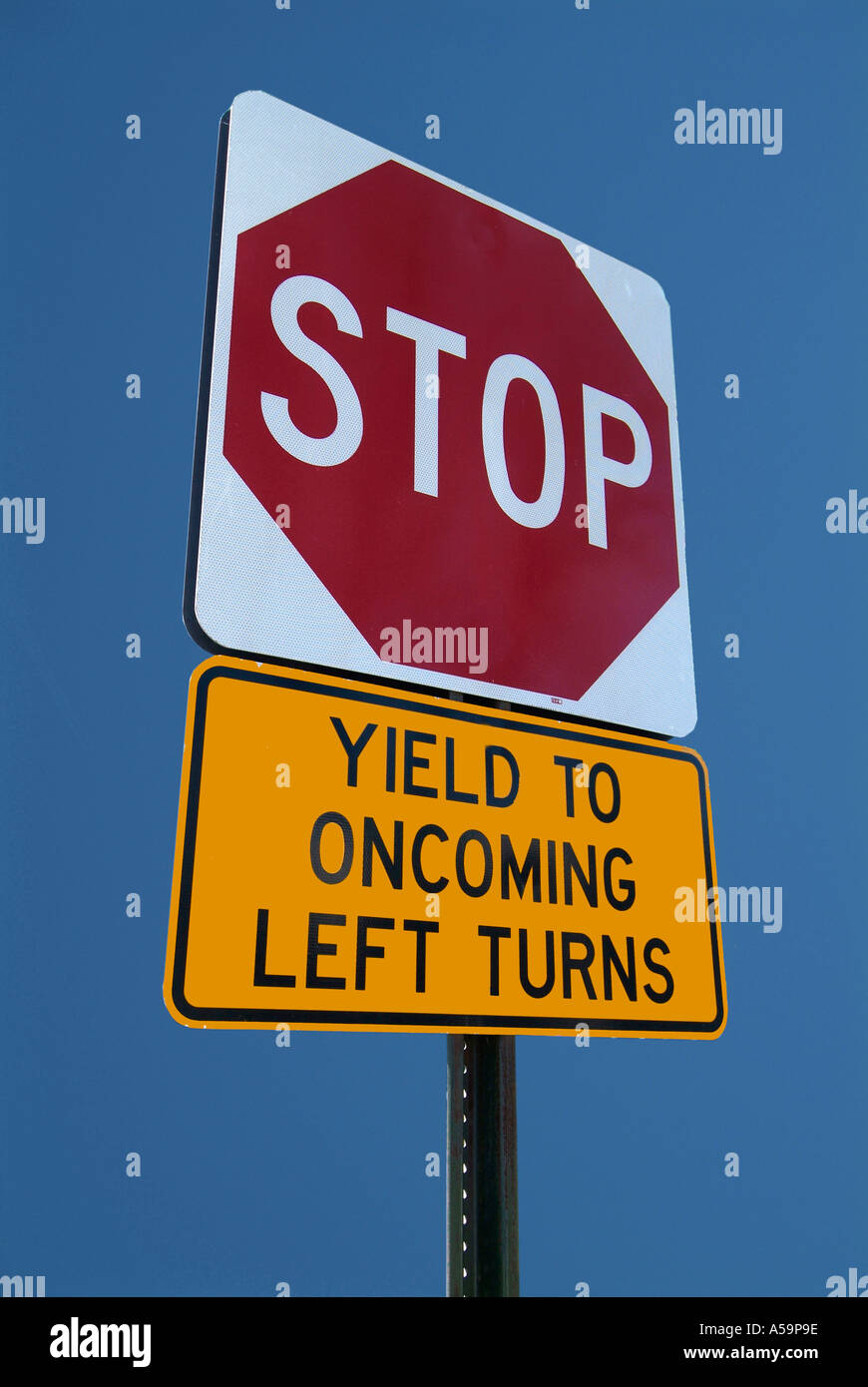Stop sign with a yield to oncoming left turn sign Stock Photo - Alamy