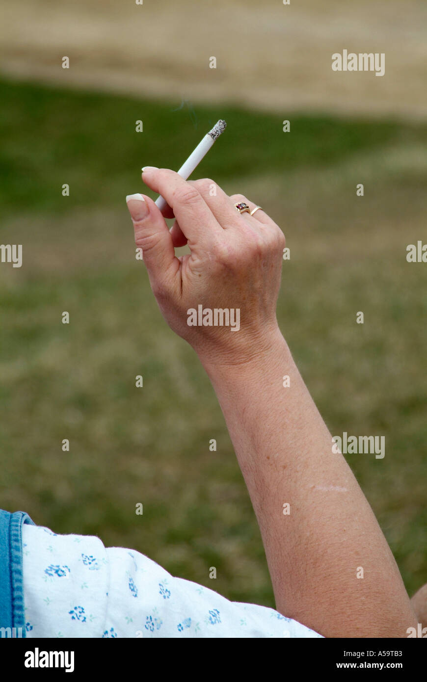Smoking cigarette in the hand of an adult female Stock Photo - Alamy