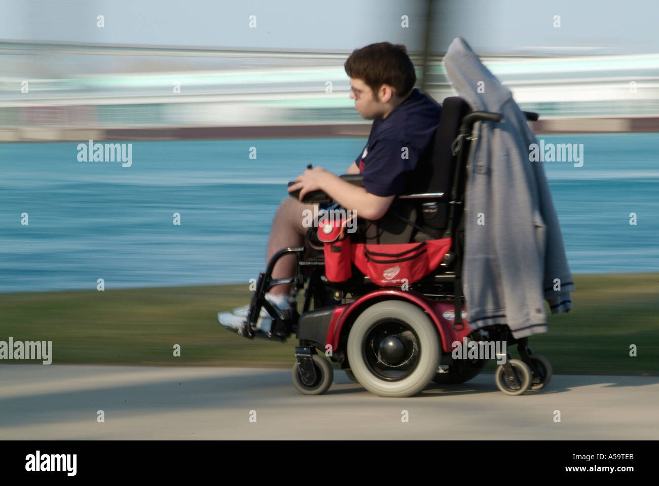 Handicapped male rides in motor powered wheelchair outside Stock Photo ...