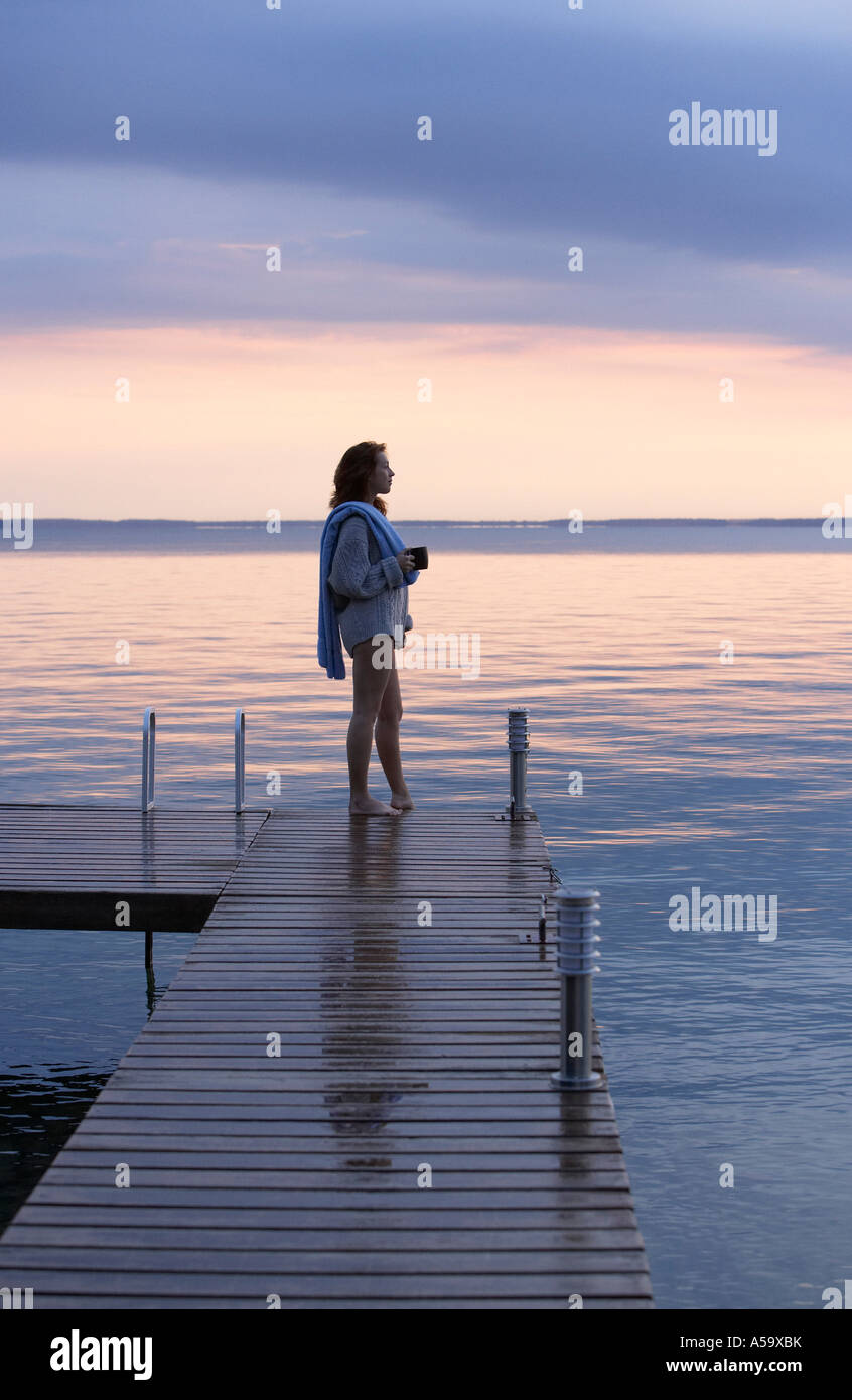 Woman on Dock by Water Stock Photo - Alamy
