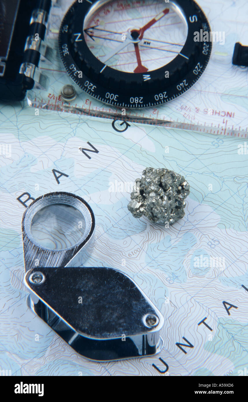 Mining concept compass magnifier mineral and map Stock Photo - Alamy