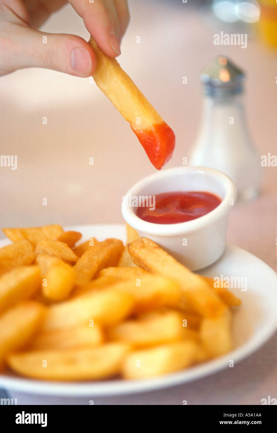 Dipping fries in ketchup on counter of American style diner Stock Photo ...
