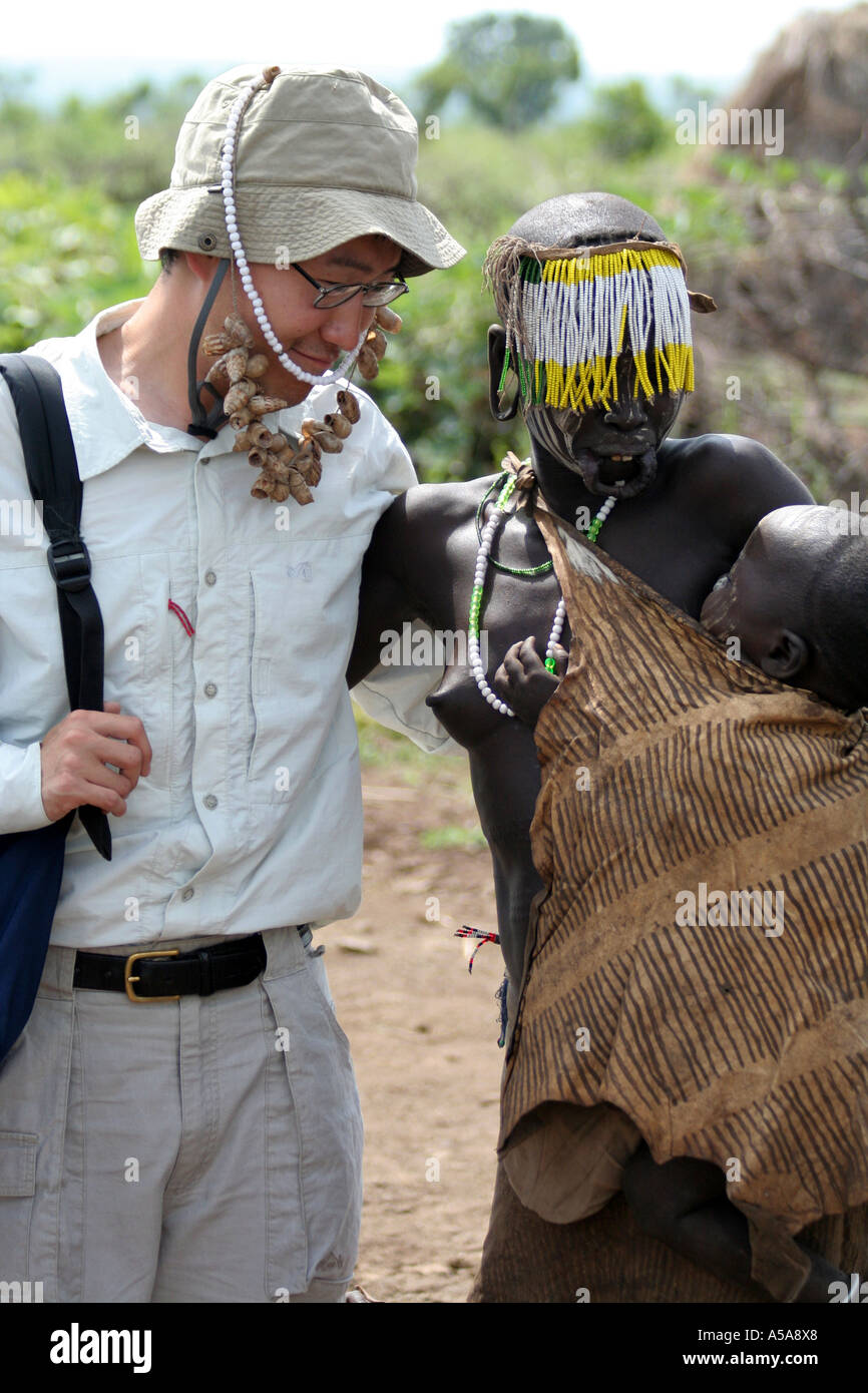 Mursi Tribe woman with baby and a foreign visitor, Lower Omo Valle ...