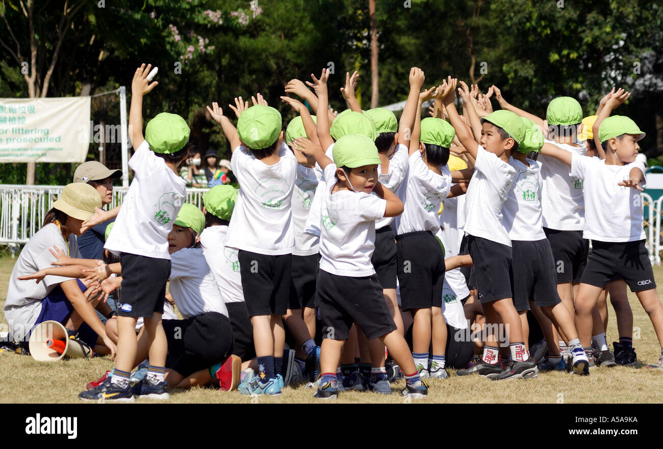 Small boy looks back from School kids in a group cheer in Victoria Park ...