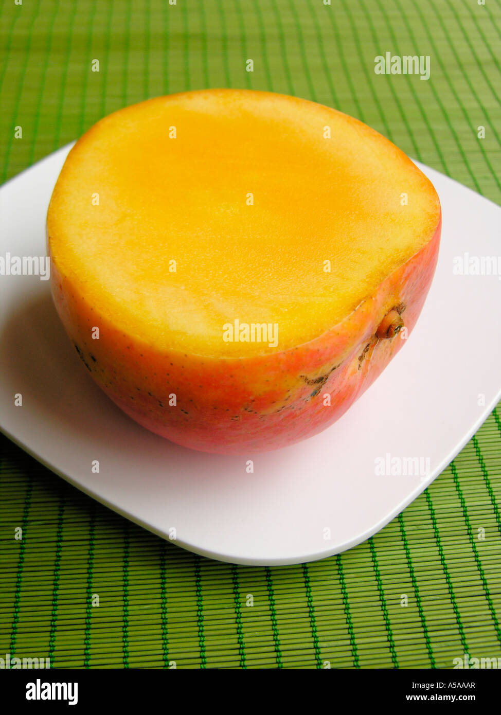 Big mango cut open on white plate Stock Photo - Alamy