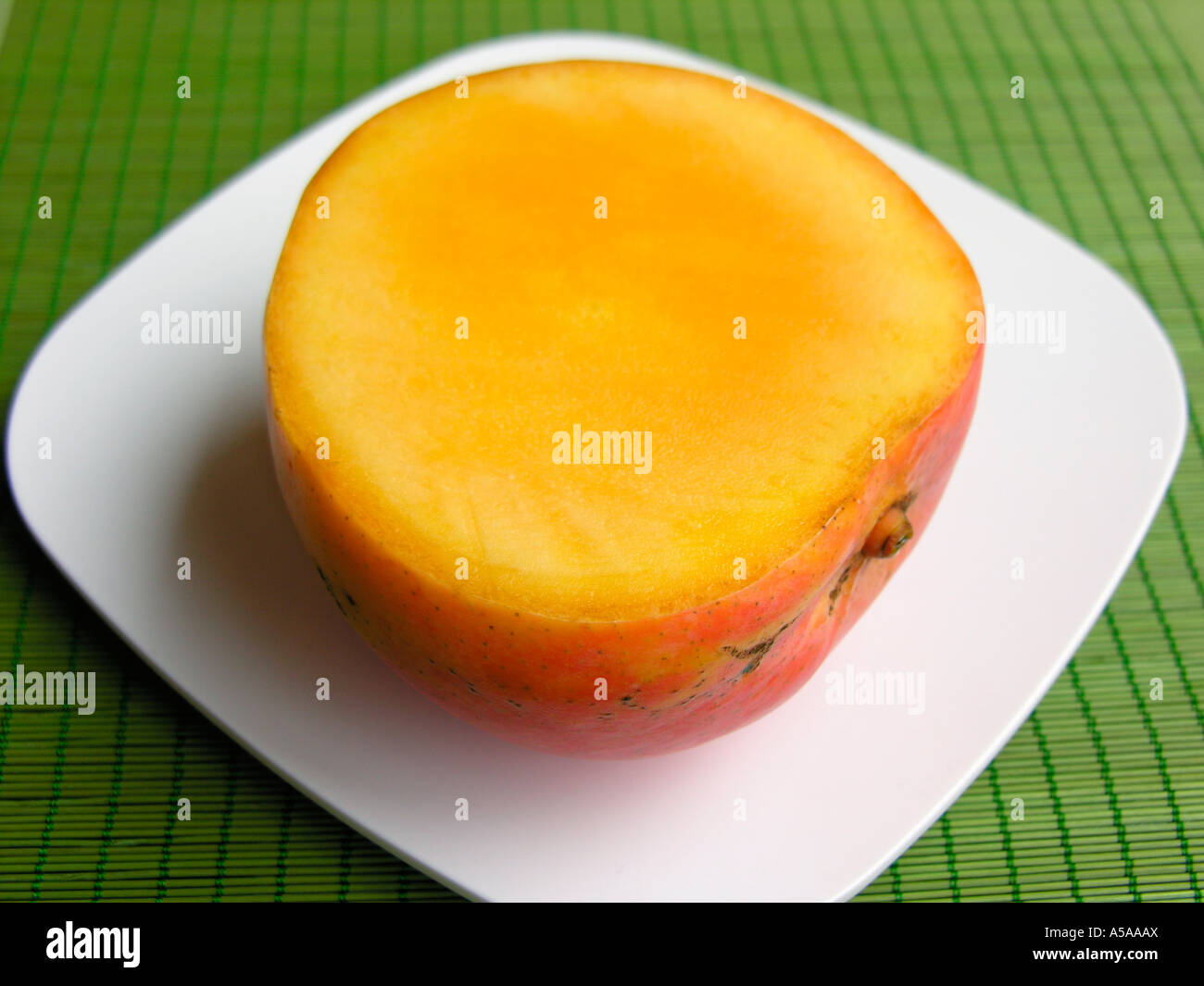 Big mango cut open on white plate Stock Photo - Alamy