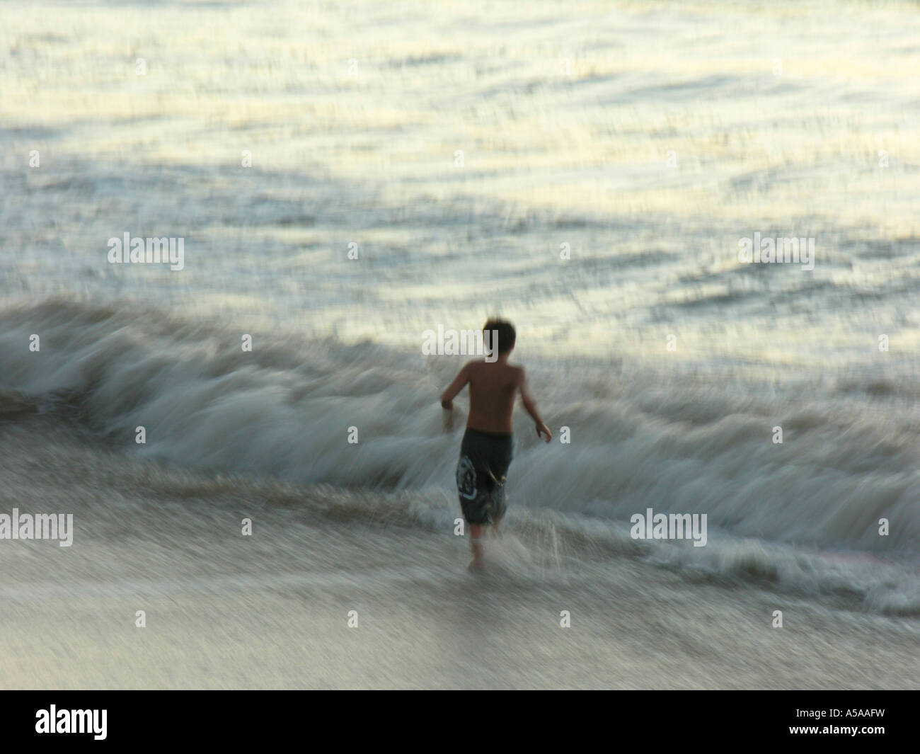 Young boy running into sea Stock Photo - Alamy