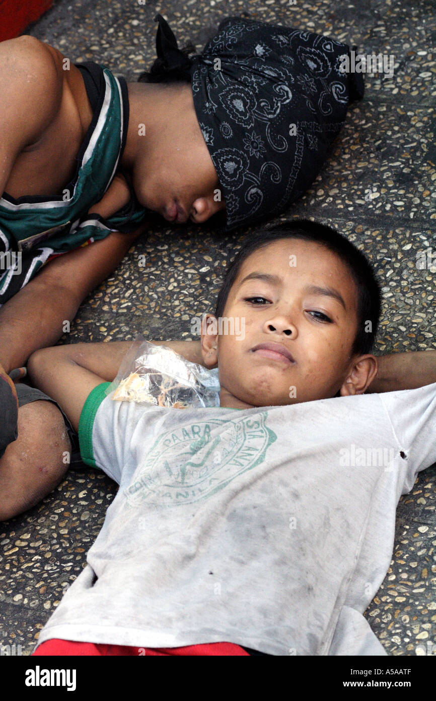 Homeless boys sleeping on the street in Manila, Philippine Islands ...