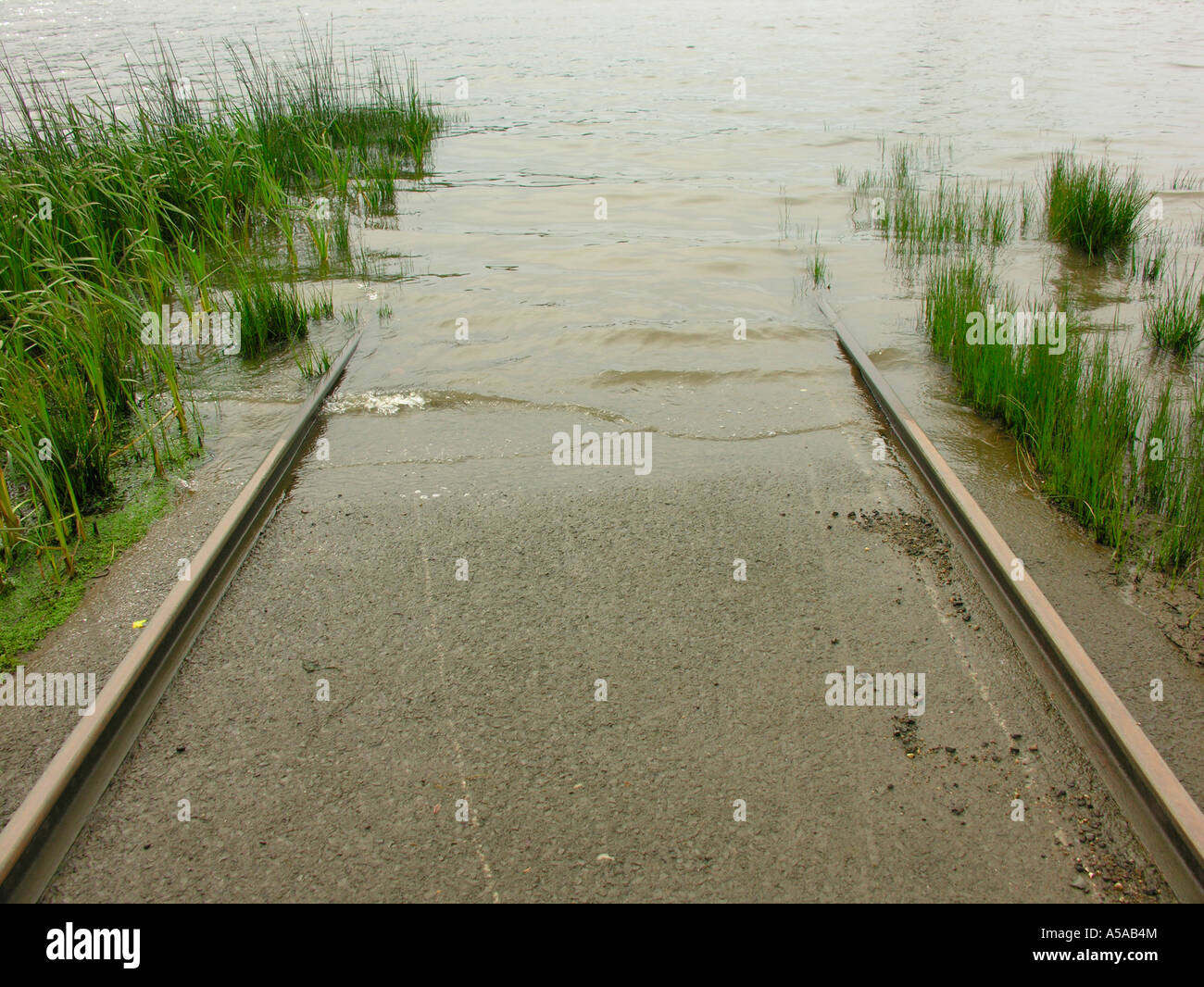 Railway track leading into water Stock Photo - Alamy
