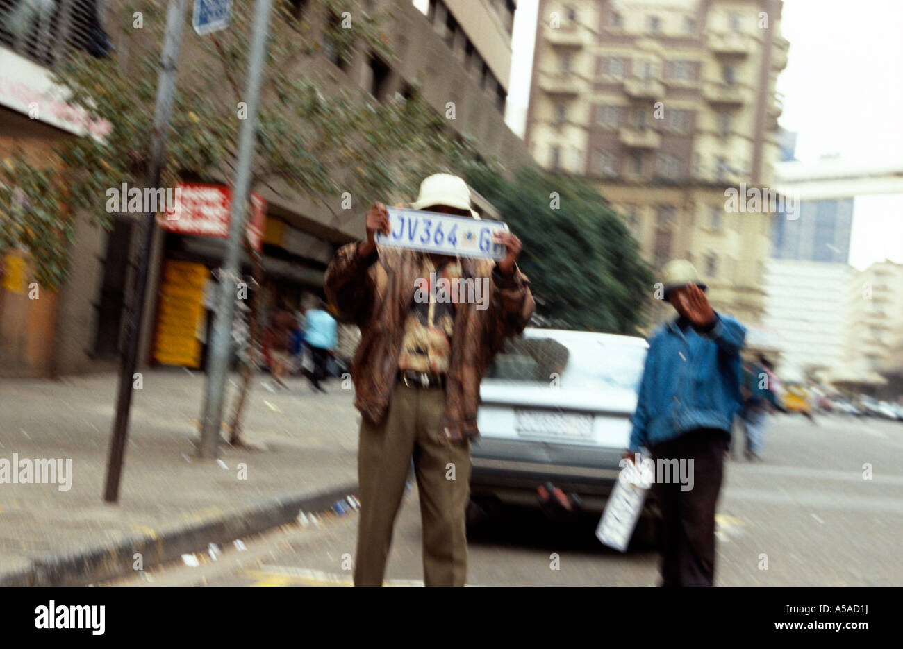 Men holding up license plates on the street Stock Photo - Alamy
