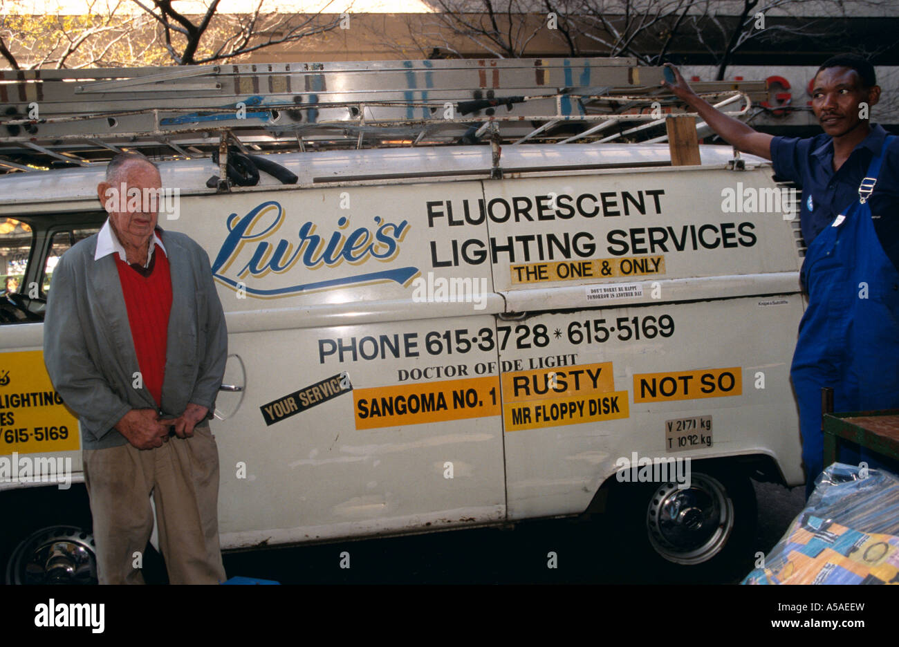 Workers providing lighting services standing with the company s van ...