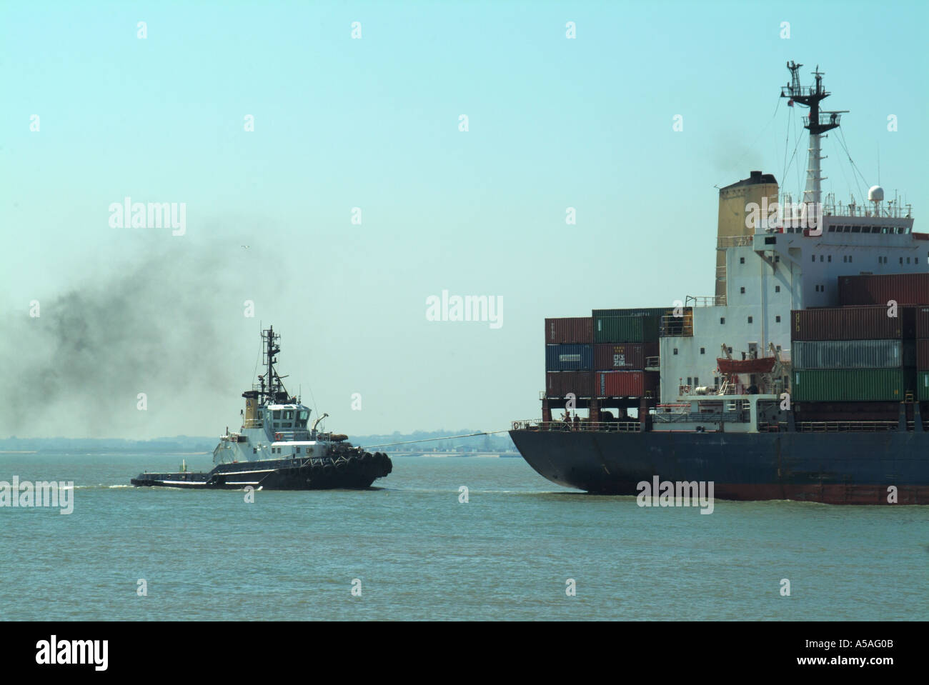 Felixstowe port and stern of loaded container ship with tugboat ...
