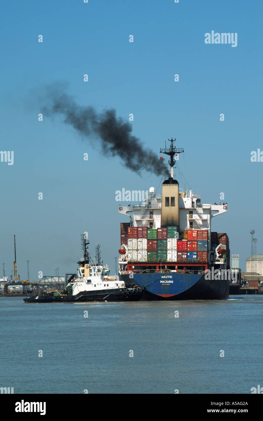 Arriving cargo container freighter ship & black smoke stacked with load ...