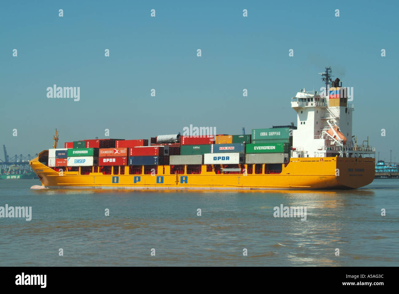 Side port view of small yellow container cargo freighter ship loaded ...