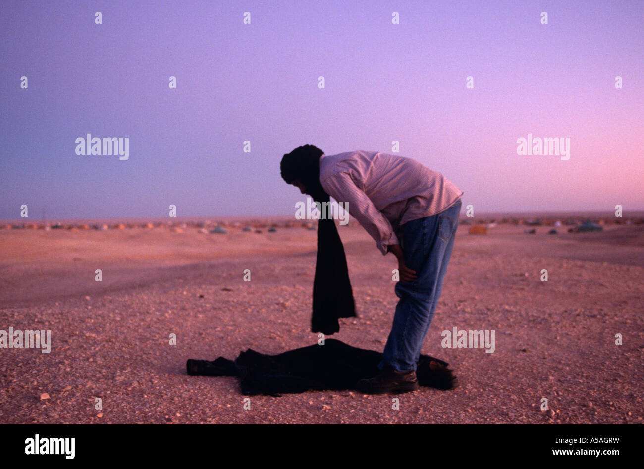 A muslim man performing his daily ritual prayers at the refugee camp in ...