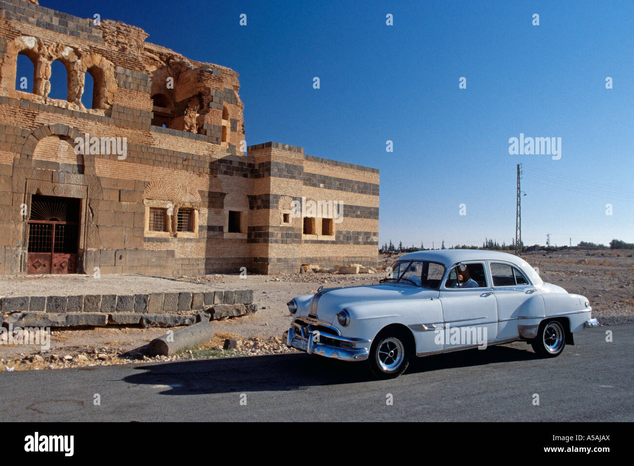 A car driving past a ruined building in Syria Stock Photo - Alamy