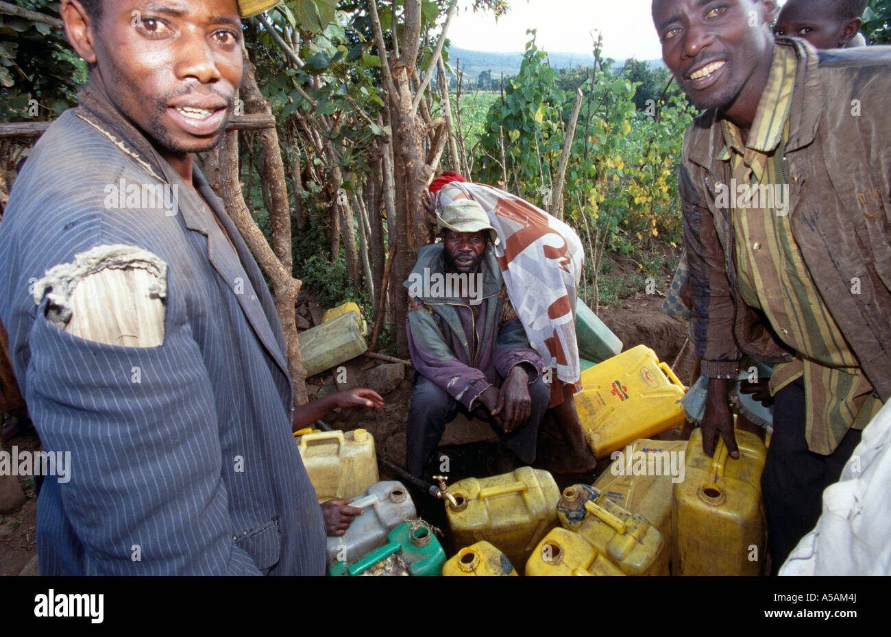 People with their containers line up to fill water in Western Uganda ...