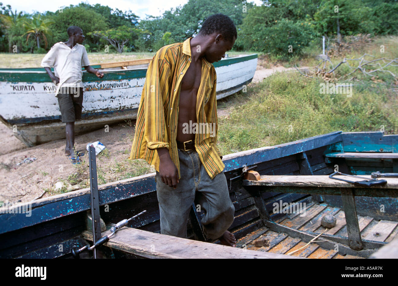 A man fixing his boat in Malawi Africa Stock Photo - Alamy
