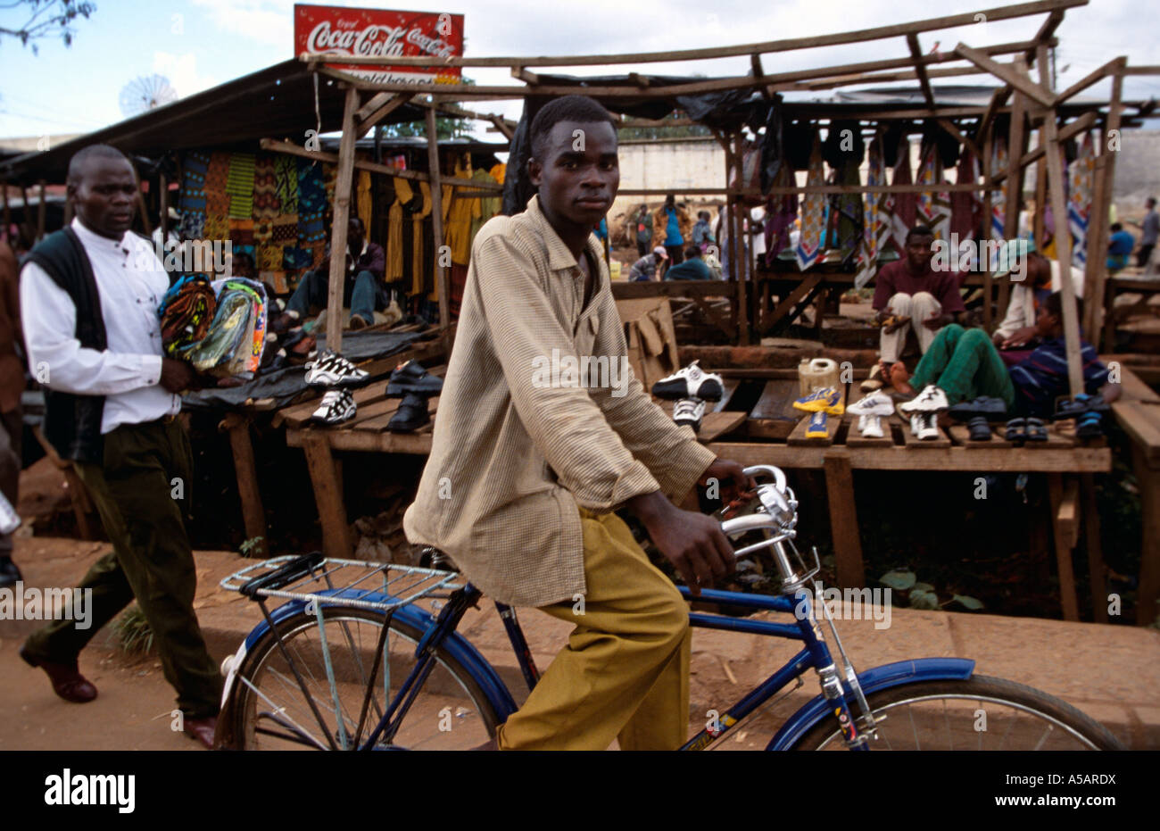 Man riding a bicycle in a street market in Rwanda Africa Stock Photo ...