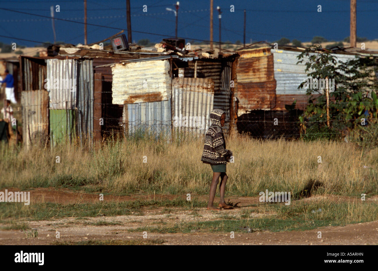 A child walking outside shacks in South Africa Stock Photo - Alamy