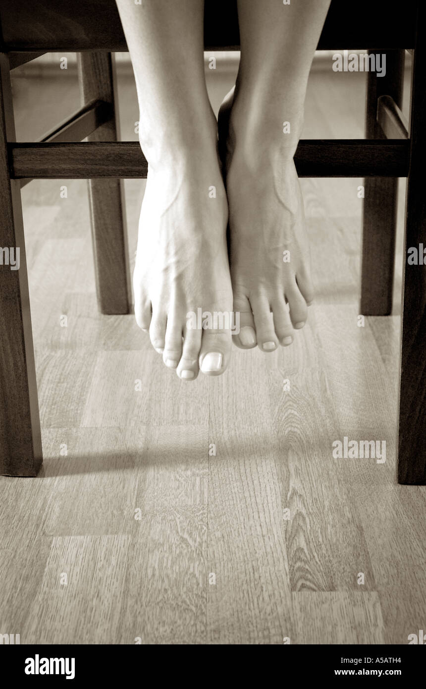 Woman barefoot sitting on chair Stock Photo - Alamy