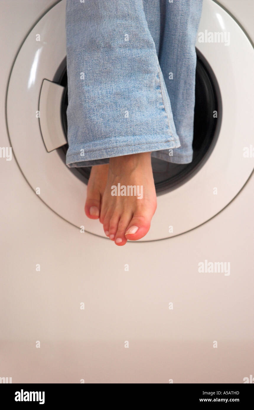 Young woman sitting on washing machine Stock Photo - Alamy