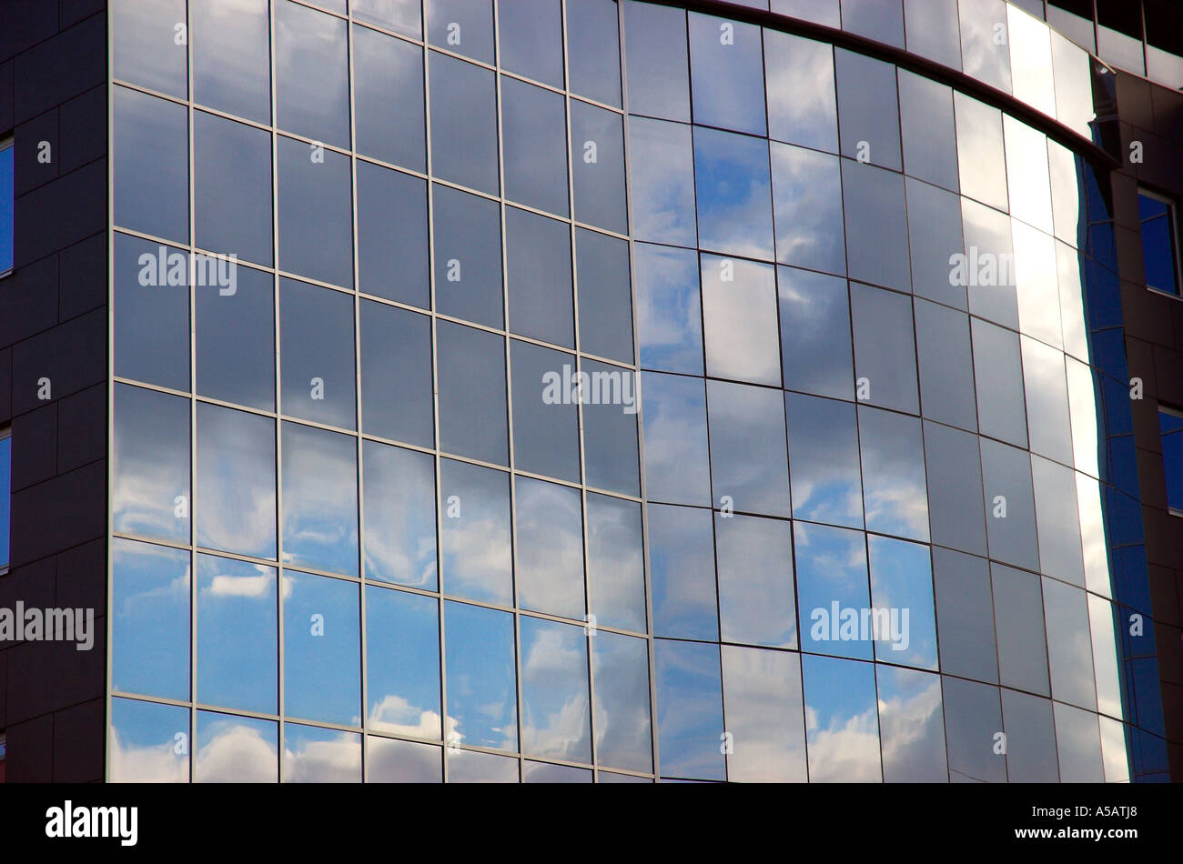 Sky and clouds reflected in modern glass facade of office building ...