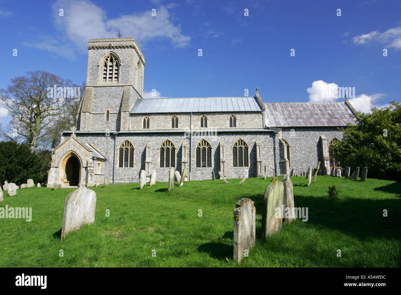 A typical Norman built English church standing in a lush green cemetary ...