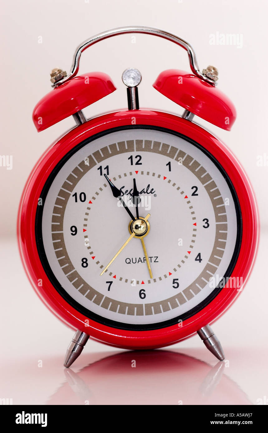 Alarm clock showing five to twelve Stock Photo - Alamy