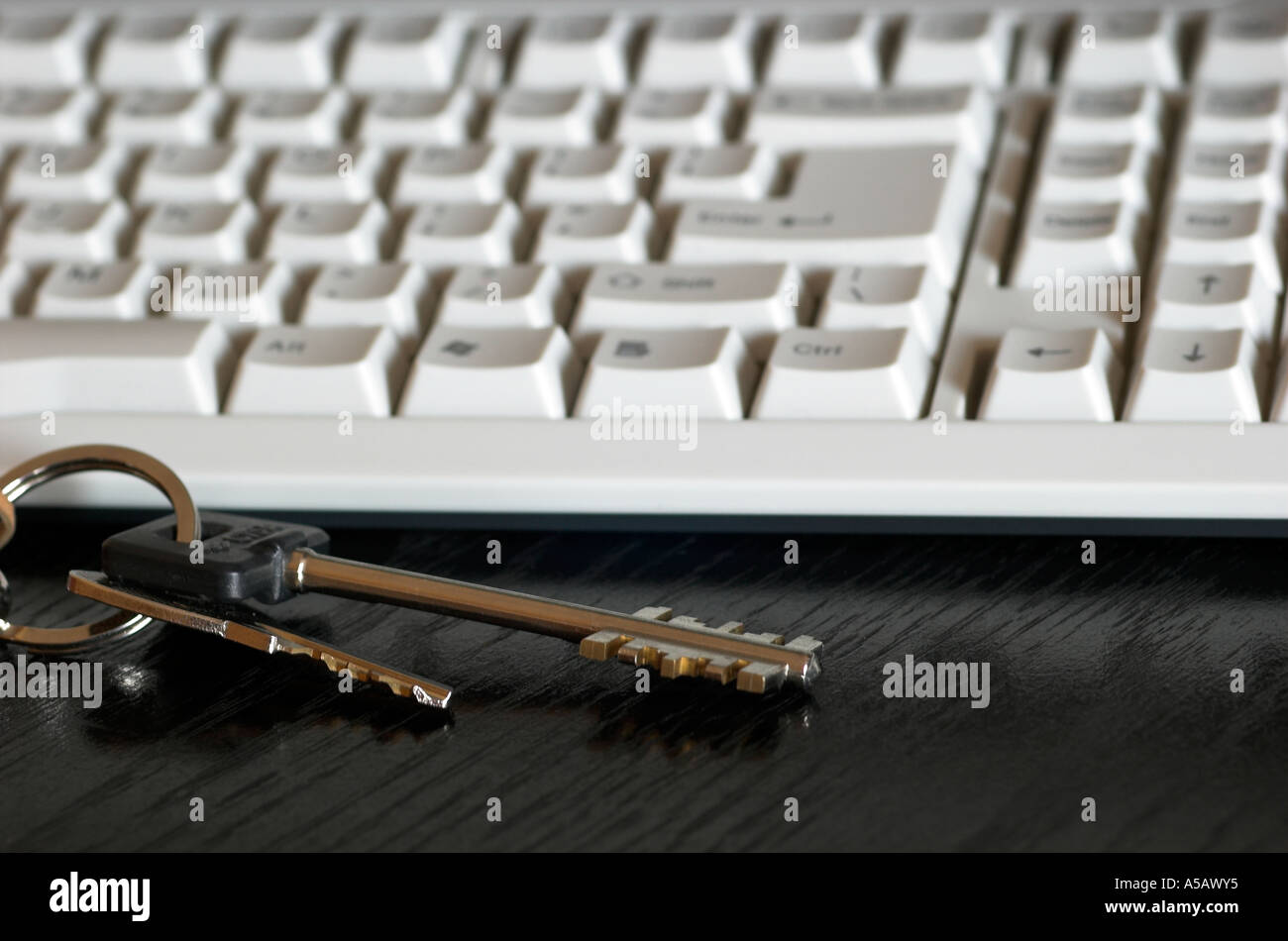 Keys on office desk next to keyboard close up view Stock Photo - Alamy