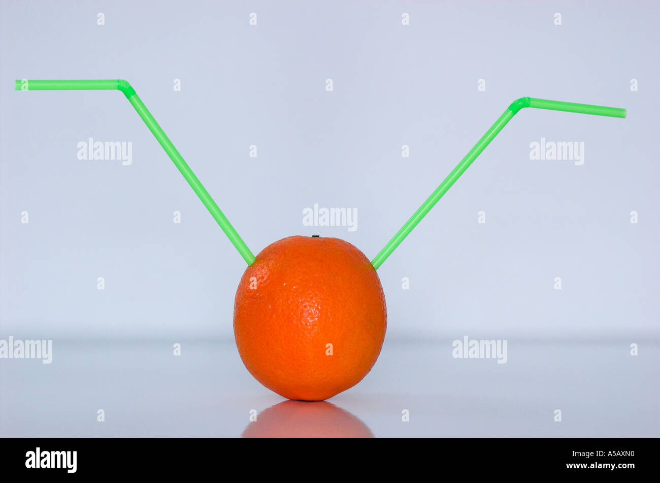 Two straws and orange Stock Photo - Alamy