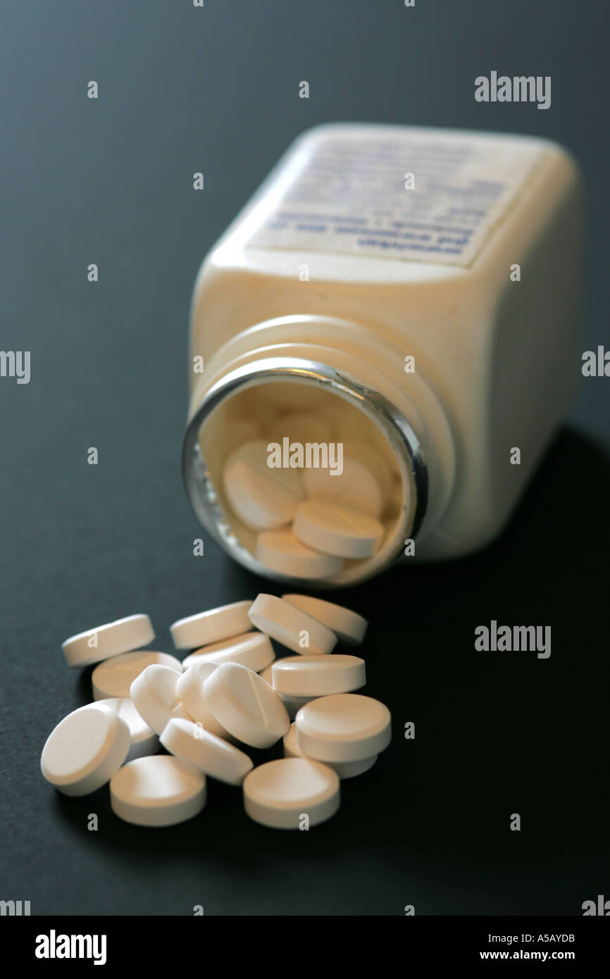 Generic white tablets pills spilling from a plain white plastic ...