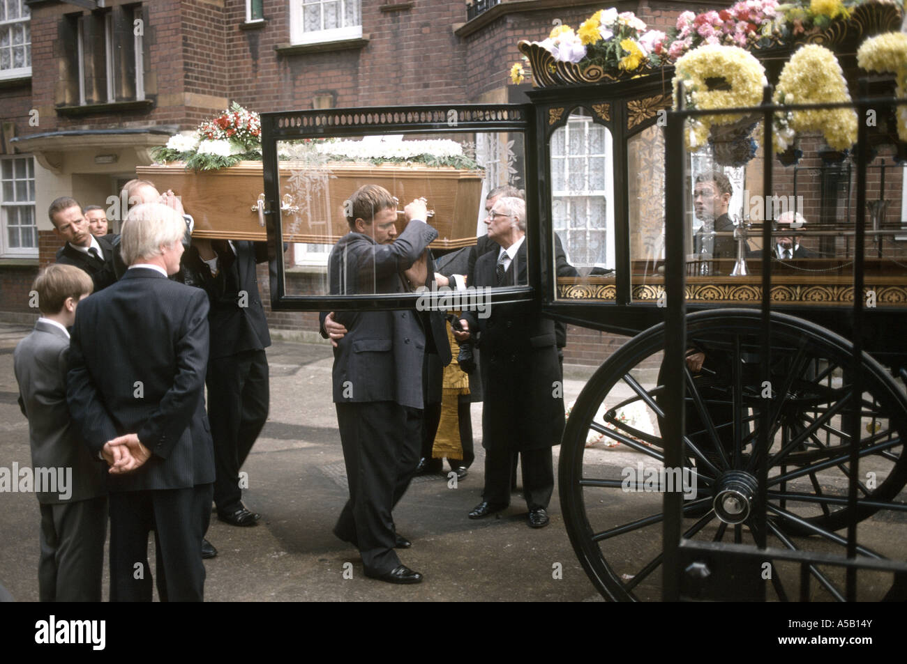 Coffin being loaded into a glass horse drawn hearse Stock Photo - Alamy