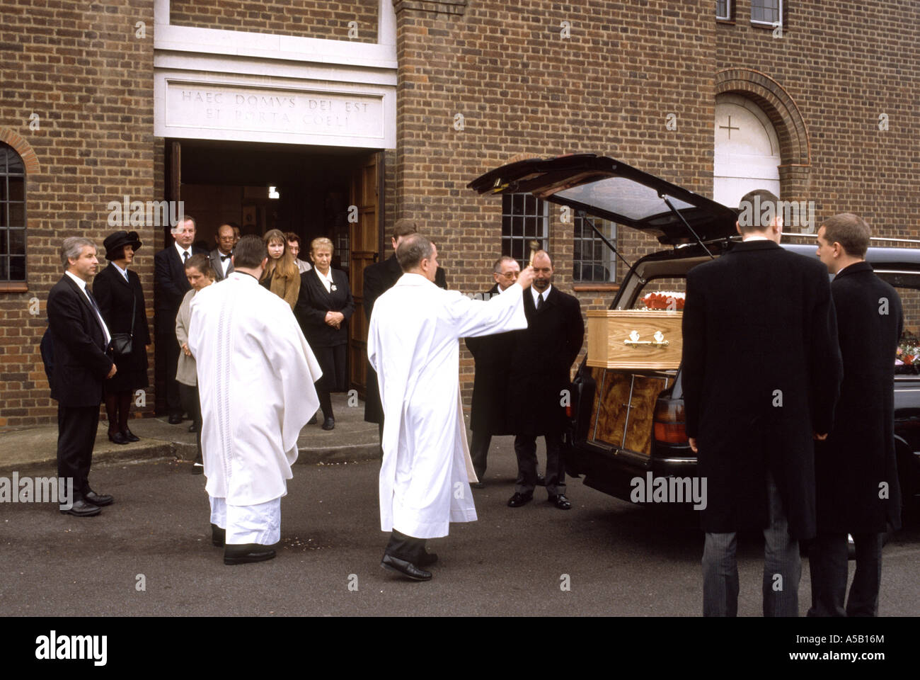 Catholic funeral where priest is blessing the coffin before it is taken ...