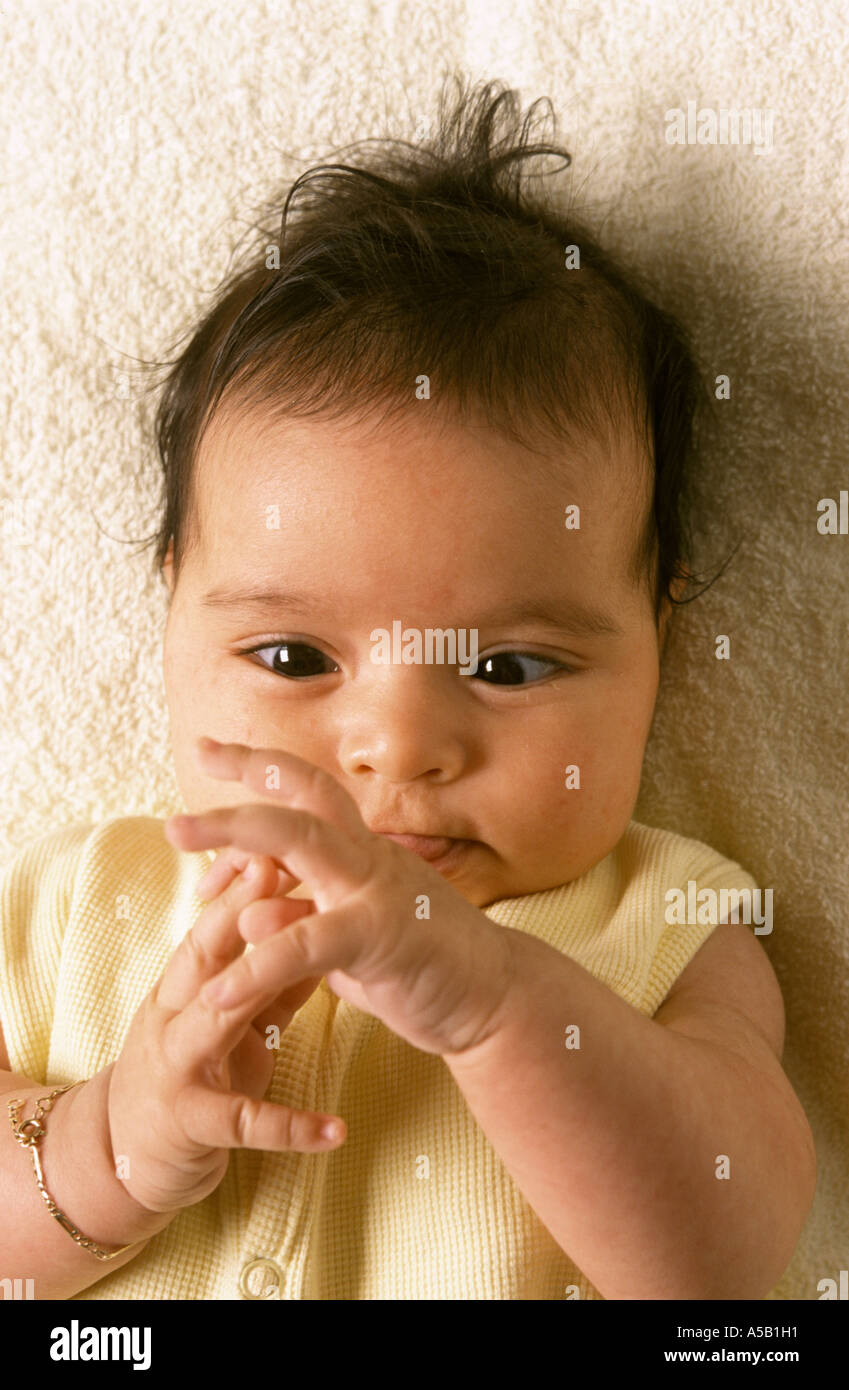Little baby playing with her hands Stock Photo - Alamy